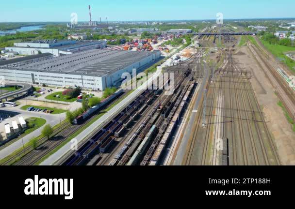 Flying above industrial railroad station with cargo trains and freight ...
