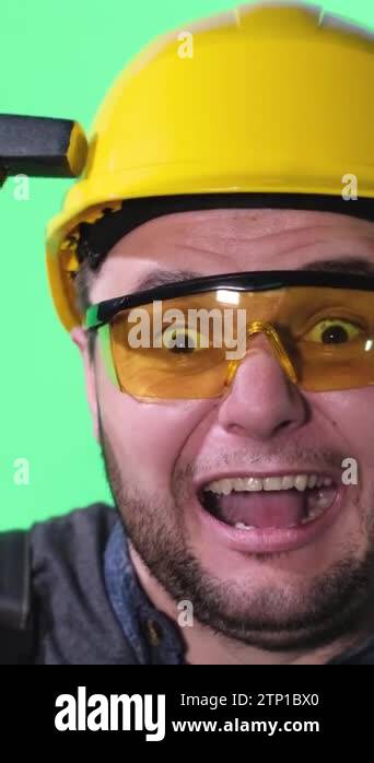 Construction worker strikes with a hammer using a hand-held metal tool ...