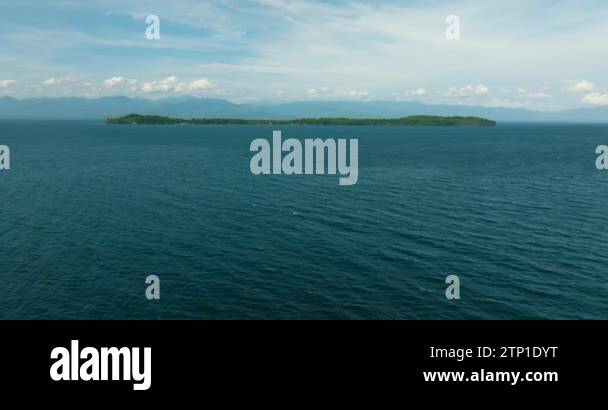 Ocean waves and tropical island. Blue sky and clouds. Samal, Davao ...