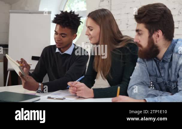 Young african guy explaining something to his collegues. Happy diverse ...