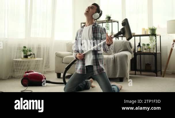 Man transforms into a rock star while cleaning his home. With a broom or vacuum cleaner as his ...