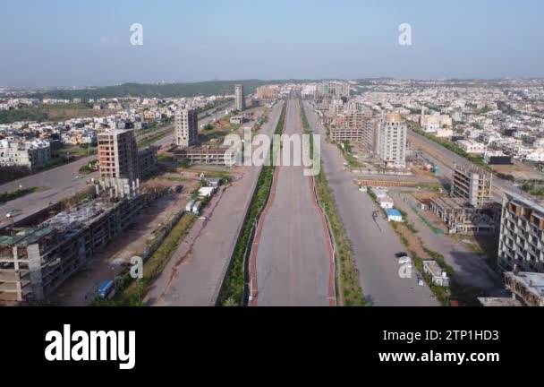 As you follow the straight road, a dynamic urban scene comes into view ...