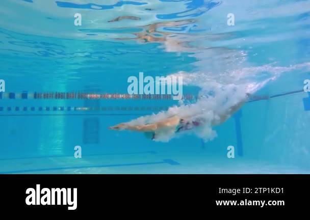 Woman athlete swims underwater in the pool. Slow motion of a female ...
