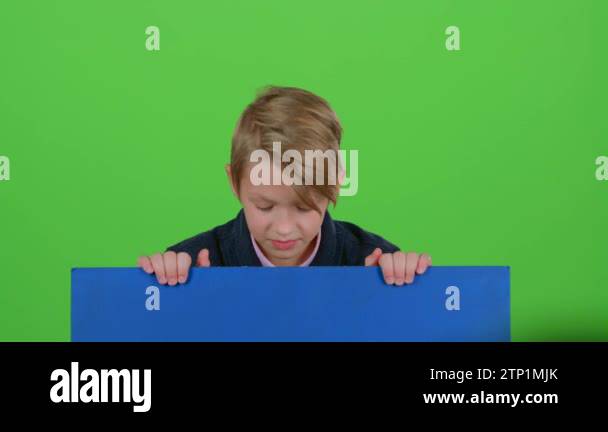 Child boy appeared from behind a blue poster to look at him hiding ...