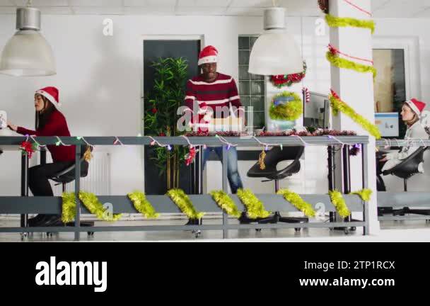 Employee in Christmas ornate workspace dancing around, happy to be ...