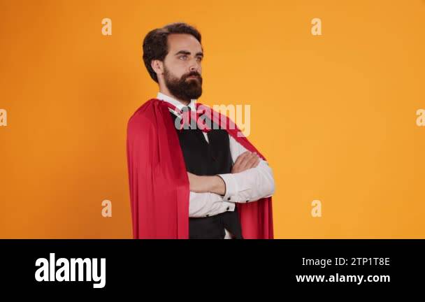 Powerful fantasy hero with red cape standing against yellow background ...