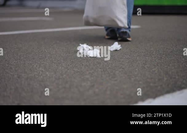 Female feet walking on parking lot gathering trash leaving. Close-up ...