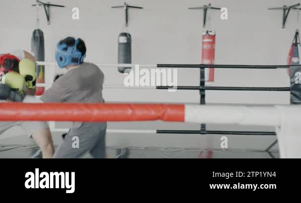 Strong young men fighting in boxing ring sparring together concentrated ...
