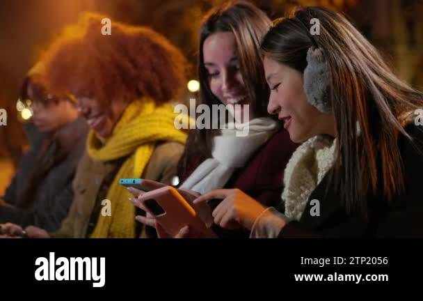 Hipster group of millennial friends using cell phones sitting together ...