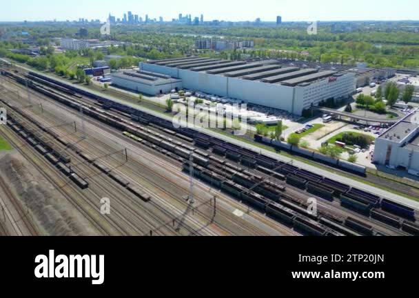 Flying above industrial railroad station with cargo trains and freight ...