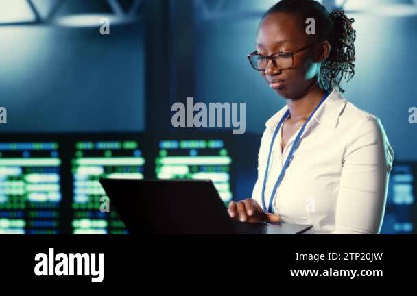 Woman walking through high tech facility server rows providing computing resources for different ...