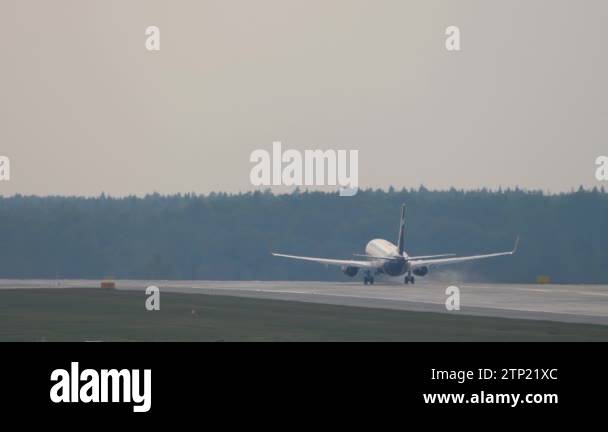 Jet passenger plane with unrecognizable livery taking off, rear view ...