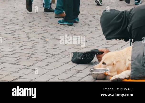Poor man kneels on the pavement with his outstretched hand and black ...