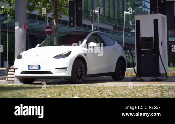 Europe, Italy, Milan 08-25-23 - Tesla electric car is charging the ...