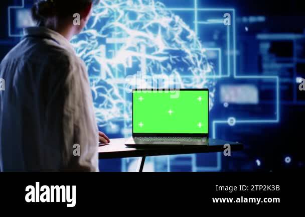 Proficient worker using green screen laptop to implement artificial intelligence parallel ...