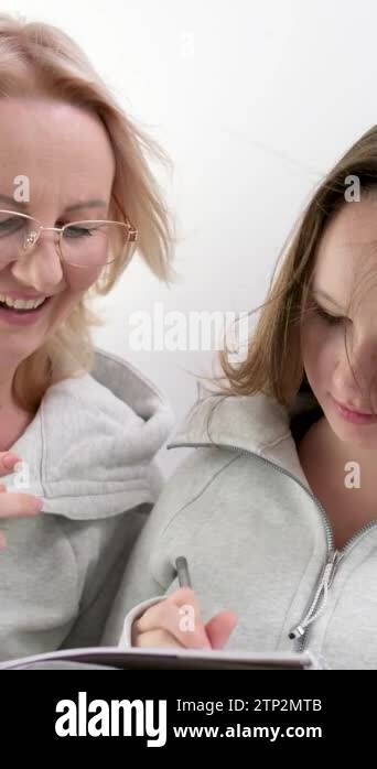 mom and daughter doing homework, woman wearing glasses, young teenage ...