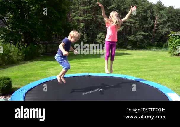 two kids jumping on trampoline Stock Video Footage - Alamy