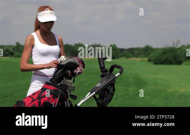 Pretty redhead woman taking golf club from the golf bag. Attractive ...