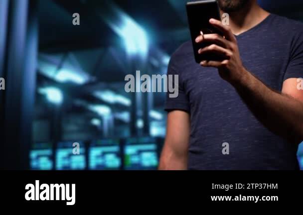 Man engineer working in server room using phone to check tech ...