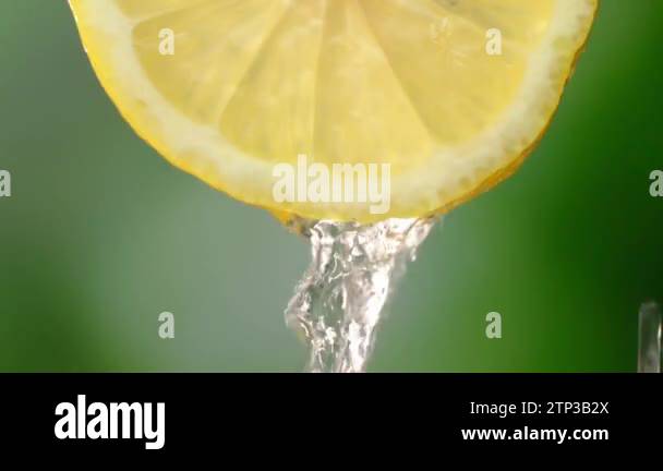 Super slow motion footage of sliced lemon slices with splashes of water ...