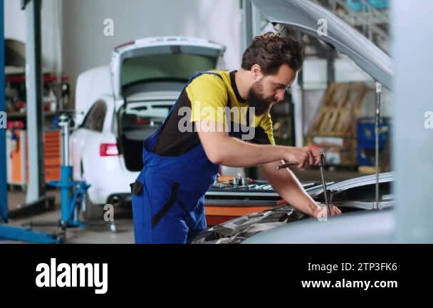 Mechanic in car service uses torque wrench to tighten bolts inside ...