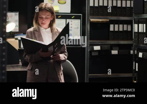 Female private detective conducting investigation in office, focused on ...