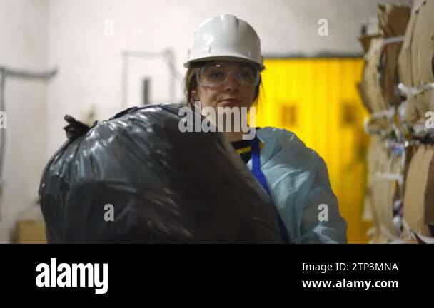 Serious woman with garbage bag walking on recycling station as live ...