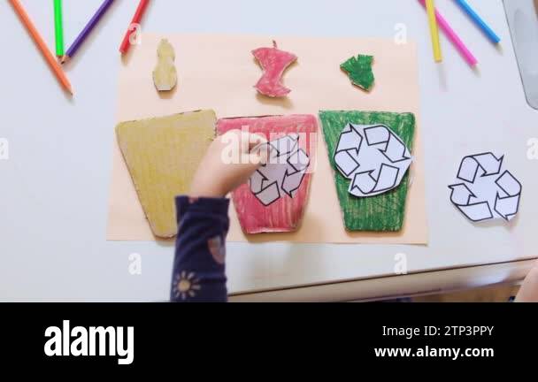 Little girl playing with poster of garbage containers for sorting at ...