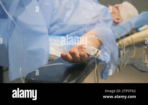 An elderly woman, a grandmother, is on the operating table, having a ...