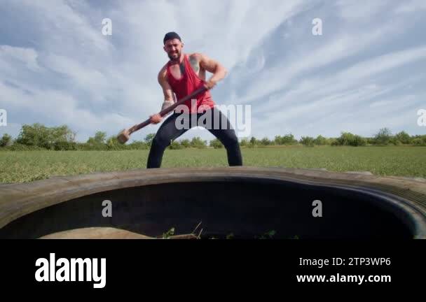 Muscle and Determination Powerful Man Hits Tire with Hammer in Training ...