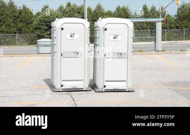 two gt gray portable toilets porta potties next to each other in ...