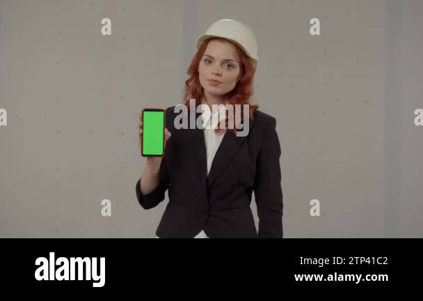 A female architect is holding smartphone screen facing forward ...