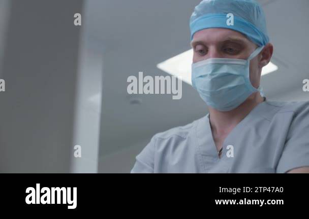 Professional surgeon in uniform cleans hands before surgery. Male medic ...