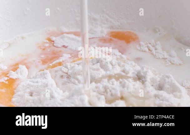 Water adding to cereal flour with egg for homemade bread preparation ...