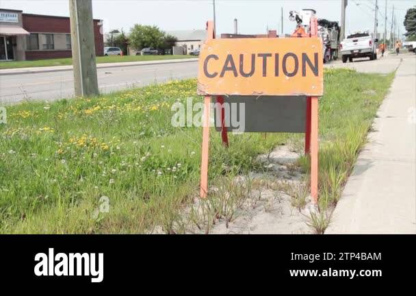 caution word caption text sandwich board wooden sign next to sidewalk ...