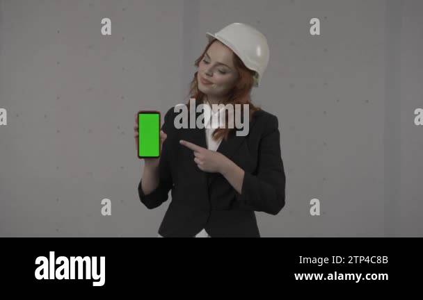 A female architect is holding smartphone screen facing forward and ...