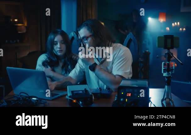 Medium-sized video of a ghost hunter and a victim sitting at the table in a dark room. Another ...