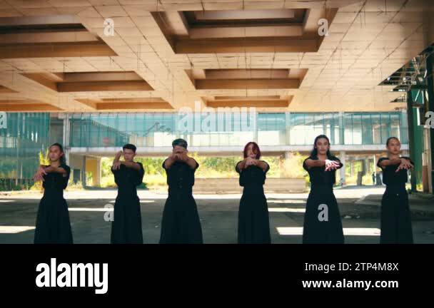 a group of Asian men in black clothes dancing with their hands and full ...