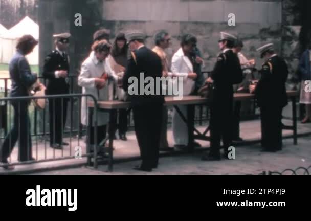 Police officers conducting security checks and inspecting visitors bags ...