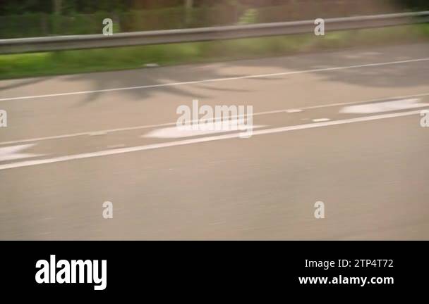 View from car side window on a fast-moving road markings pass by on ...