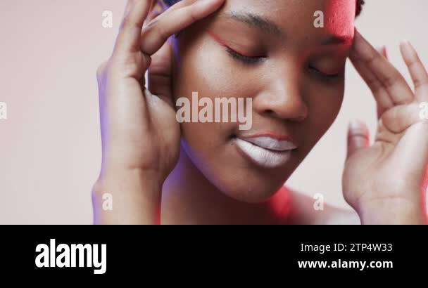 African american woman with short dark hair in blue and pink light ...