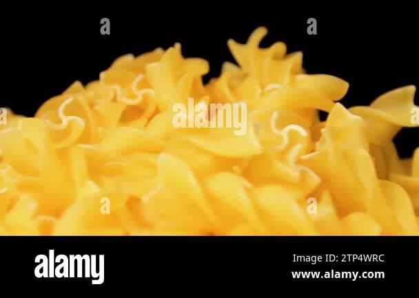 Uncooked Fusilli Pasta Heap Rotating against Black Background. Fat and ...
