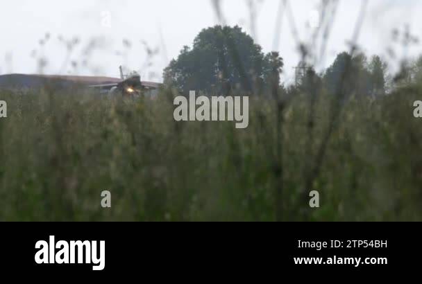 Combat fighter jet expertly lands in the rain, partially concealed by ...