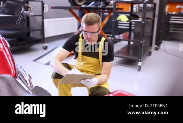 Foreman in service repair center diagnoses parts on motorcycle. Service ...