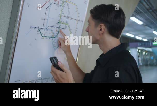 Profile view man looking for way on map, pointing on metro network map ...