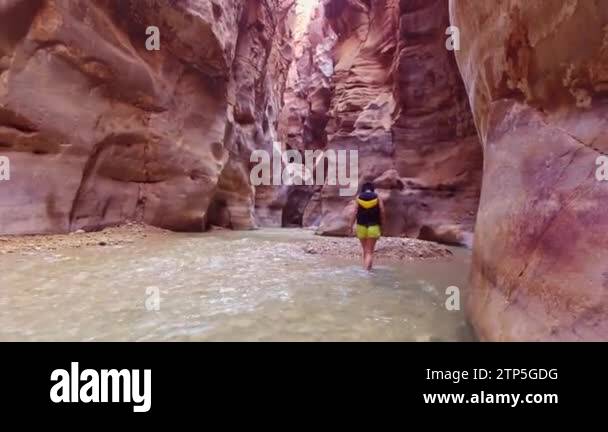 Female tourist walk in water in famous river canyon of Wadi Mujib in ...