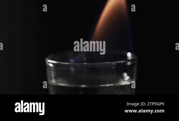 Video of lit alcohol in glass with orange fire flame and copy space on ...