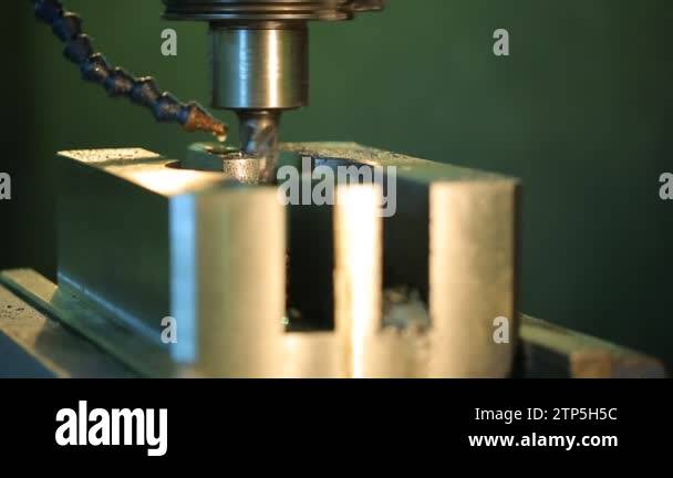 Rotating a drill a vertical drill press handles metal piece with a ...