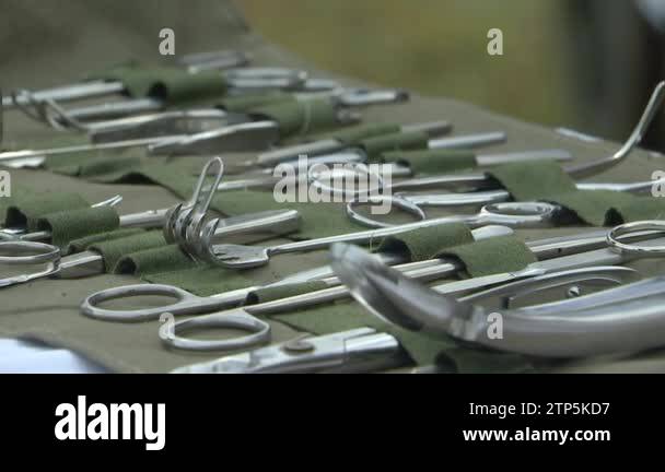An operating nurse lays out surgical instruments on a table for ...