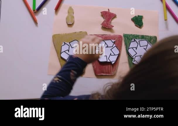 Little girl making poster of garbage containers for sorting at ...